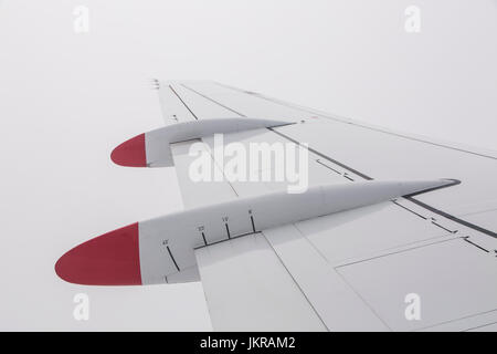 Cropped image of airplane flying against blue sky over scenic view of ...