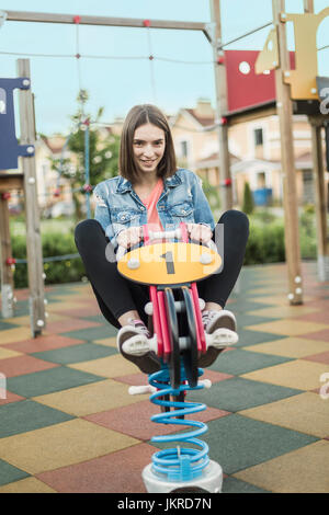 Smiling woman holding number 21 helium balloons while sitting on bed at ...