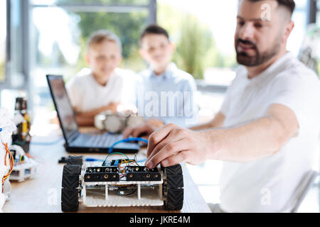 man plugging the wire into a robotic vehicle Stock Photo - Alamy