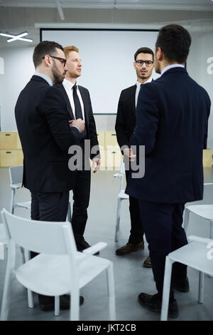 Four businessmen talking in a seminar Stock Photo - Alamy