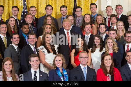 President Donald Trump poses for photos with members of the University ...