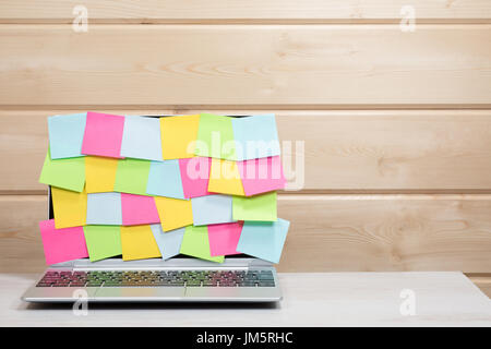 Laptop screen covered with sticky notes with different appointments on ...