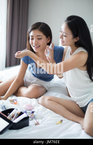 Beautiful friends holding perfume Stock Photo - Alamy