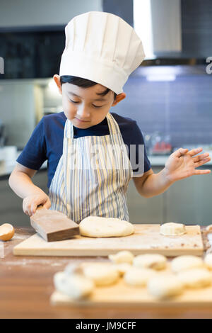 Happy little Chinese boy baking at home Stock Photo - Alamy