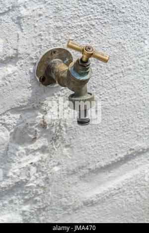 Outdoor water tap seen against the outside kitchen wall of a house in ...