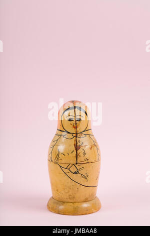 an old matrioshka on a vibrant pink background. Minimal color still ...