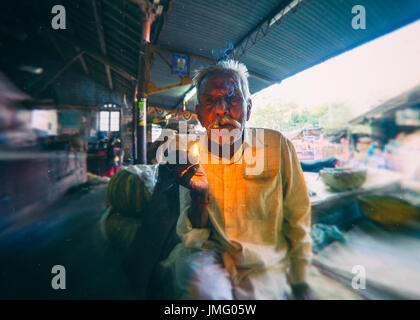 Old man smoking bidi, an Indian cigarette made of tobacco leaves or ...