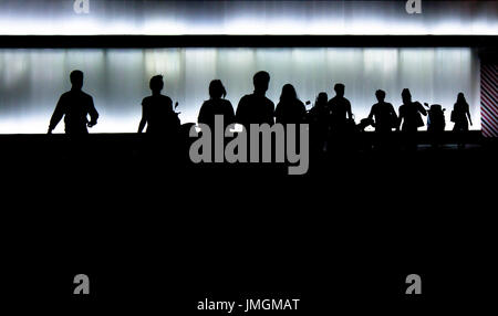 Silhouettes of people walking out of office building towards revolving ...
