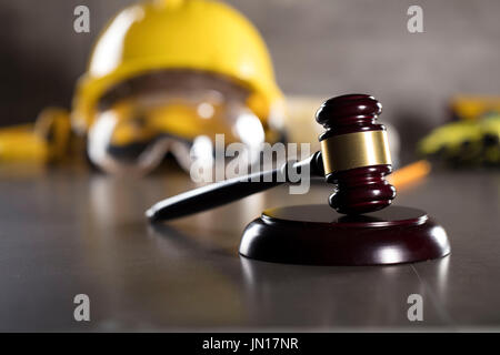 Construction law. Helmet and gavel. Stone table Stock Photo - Alamy