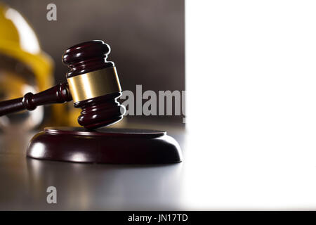 Construction law. Helmet and gavel. Stone table Stock Photo - Alamy