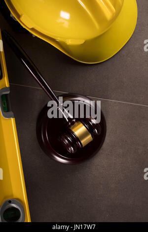 Construction law. Helmet and gavel. Stone table Stock Photo - Alamy