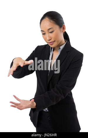 Businesswoman holding invisible object against white background Stock ...