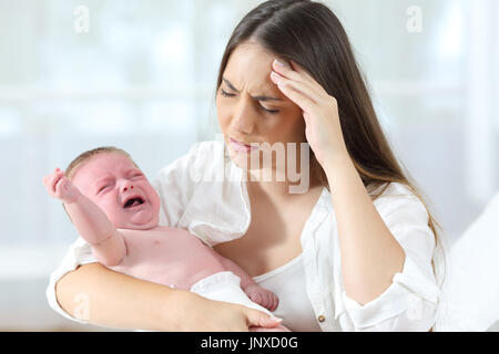Frustrated young mother holding her toddler Stock Photo - Alamy
