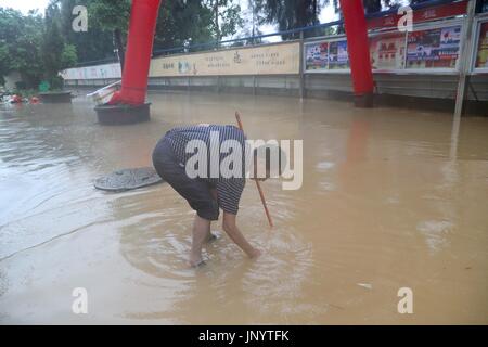 Fuqing, China. 31st Jul, 2017. Cars push through waterlogged road in ...
