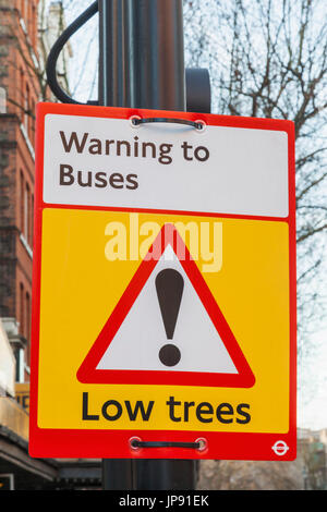 Warning to buses, low trees, warning sign in woodland near Heathrow ...
