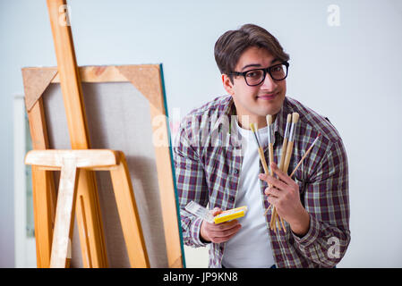 The young male artist drawing pictures in bright studio Stock Photo - Alamy