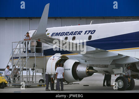 engineers inspecting inside the open CF34-8E engine cowling of ...
