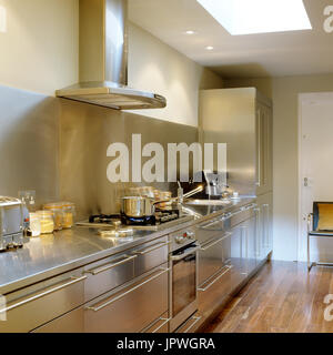 Ceiling spotlights in modern kitchen with fitted wooden cupboards and ...