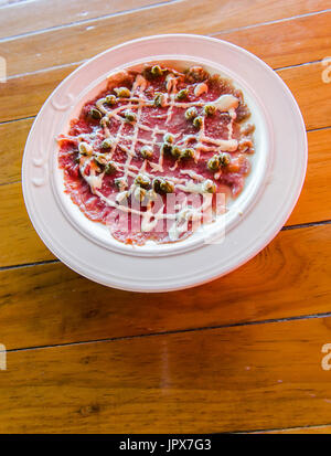 Sliced carpaccio. Raw beef meat on plate Stock Photo - Alamy