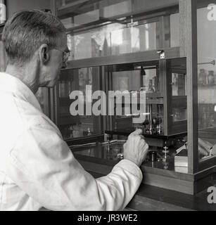 1950s, historical, male scientist in white coat working in a laboratory ...