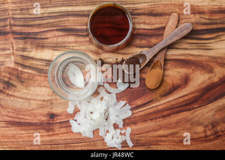 Coconut oil, coconut rashes, ground vanilla beans and maple sirup on a ...