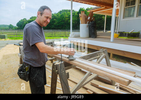 workers using electric routering to cut down stripes on the wood Stock ...
