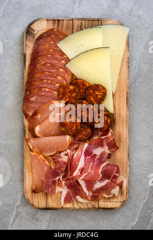 Spanish cold cuts (embutidos). Cheese, sausage and ham on gray stone ...