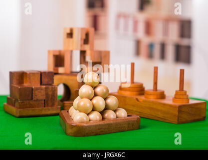 Assorted wooden brain teaser or wooden puzzles on green table in a ...