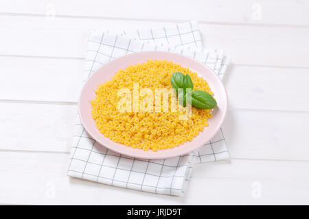 plate of small pasta shells on grey place mat Stock Photo - Alamy