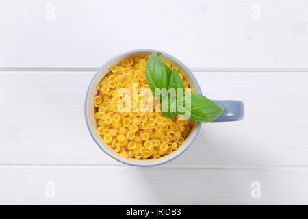 cup of small pasta shells on white wooden background Stock Photo - Alamy