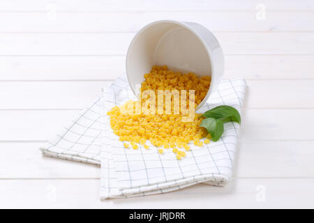bowl of small pasta shells spilt out on checkered dishtowel Stock Photo ...