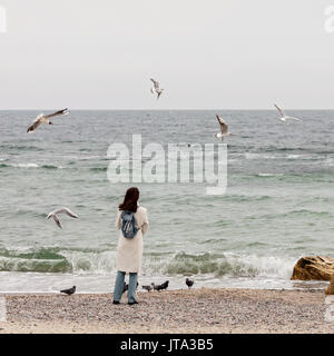 Lady in light blue coat walks down the entrance path towards the ...