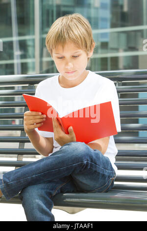 Child flipping through book pages outdoors in the city Stock Photo - Alamy