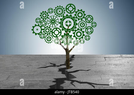 Cogwheel tree growing through soil crack Stock Photo - Alamy