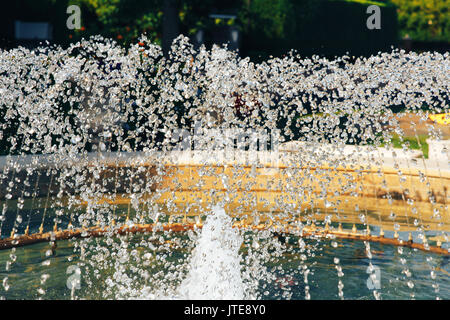Fountain splashing in still lake Stock Photo - Alamy