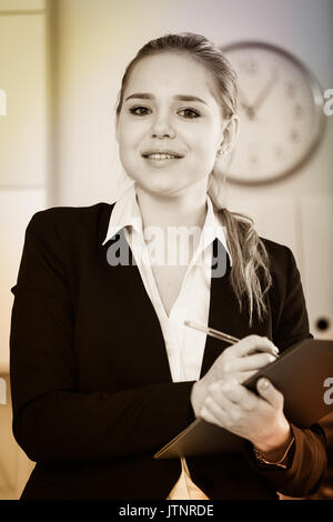 Elegant business woman writing down ideas and tasks on background with ...