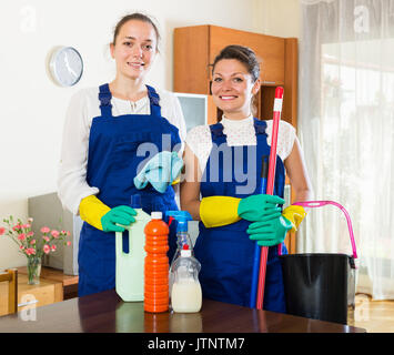 smiling cleaner washing floor while colleague cleaning desk Stock Photo ...