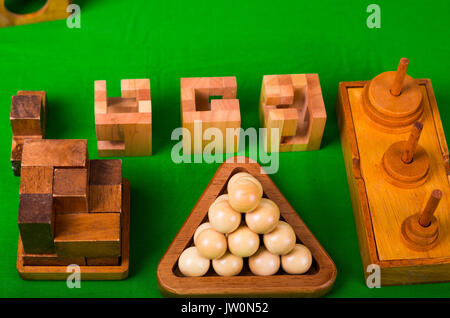 Assorted wooden brain teaser or wooden puzzles on green background ...