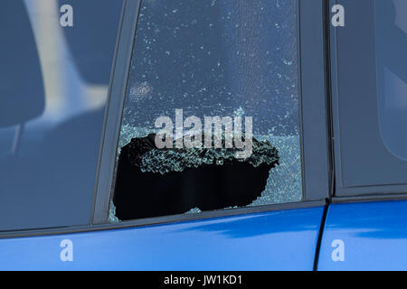 smashed broken rear car door window taped up as a temporary repair ...