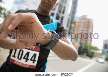 Urban Runner checking time on smartwatch Stock Photo - Alamy