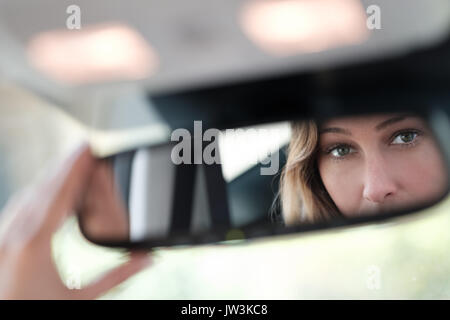 A beautiful young woman in the rearview mirror makeup Stock Photo - Alamy