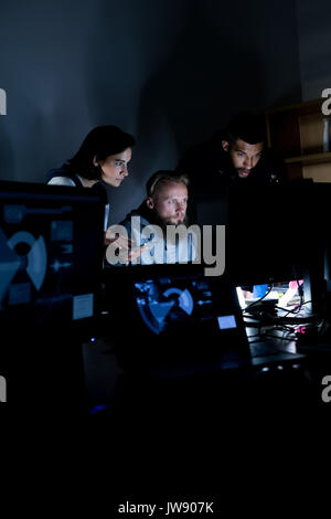 Colleagues working on personal computer at desk in office Stock Photo ...