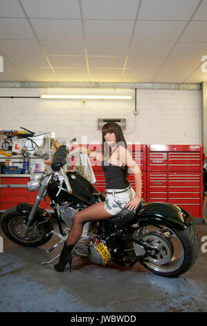 Pretty dark haired girl and a custom built chopper motorcycle in a ...