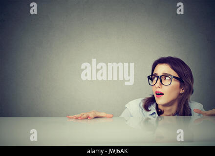 Scared Female Hiding Under Desk In Office Stock Photo - Alamy