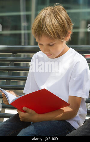 Child flipping through book pages outdoors in the city Stock Photo - Alamy