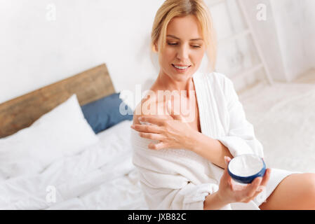 Young dreamy woman reading ingredients on package at home next to ...