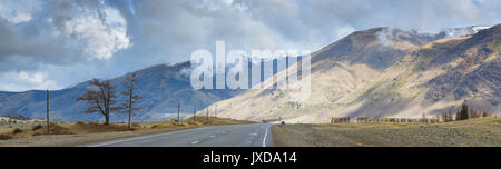 panoramic view of plain with road at root of mountains Stock Photo - Alamy