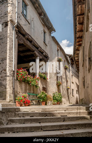 Vertical shot of an alley of old buildings under a blue cloudy sky ...