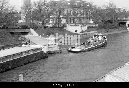 A tug boat prepares to tow a barge of refuse on the River Thames in ...