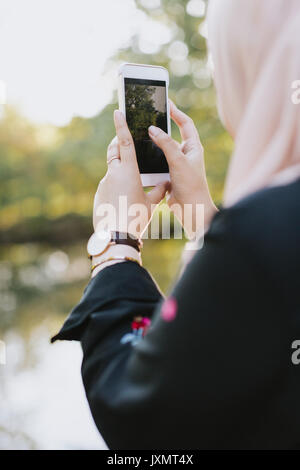 young woman taking photograph with smartphone, female using phone to ...